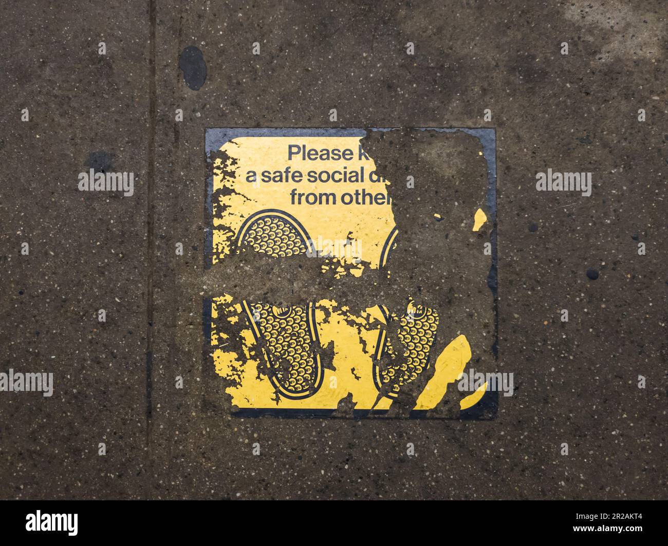 A worn social distancing sticker on the floor of a platform in the ...