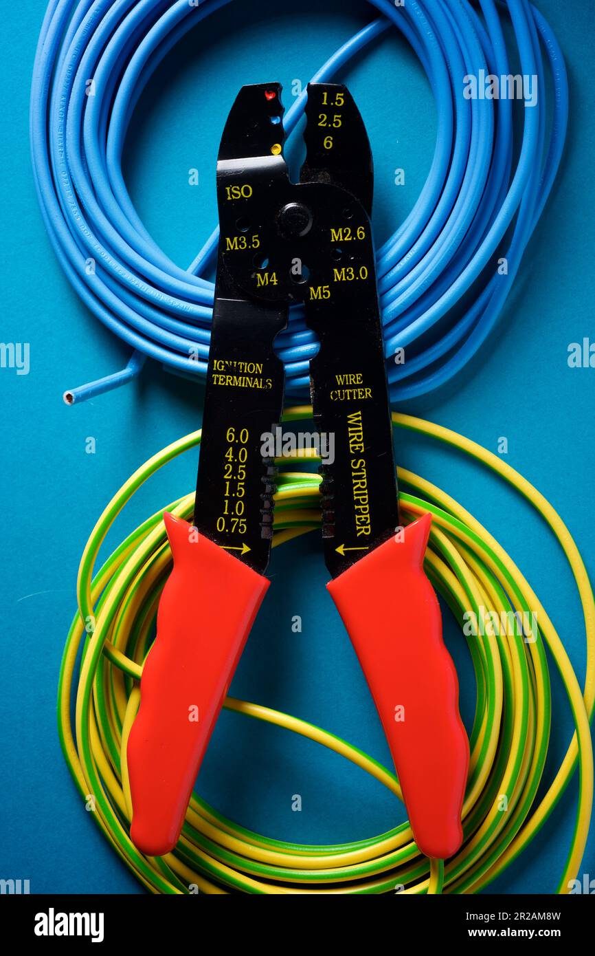 Wire stripper and cutter for cutting electric cable on a blue table ...