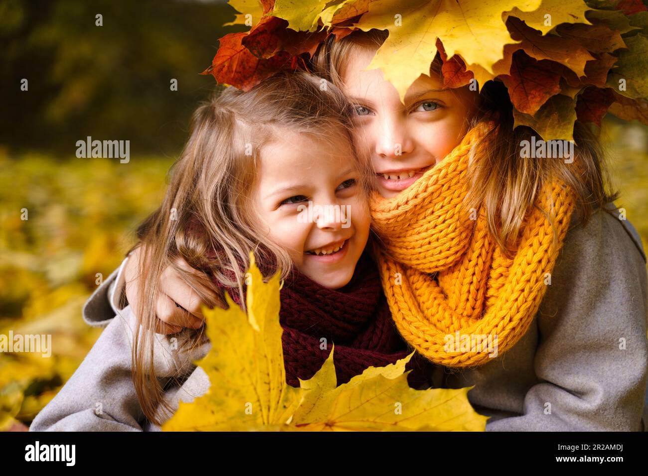 Beautiful little girls in bright yellow red orange autumn warm knitted ...