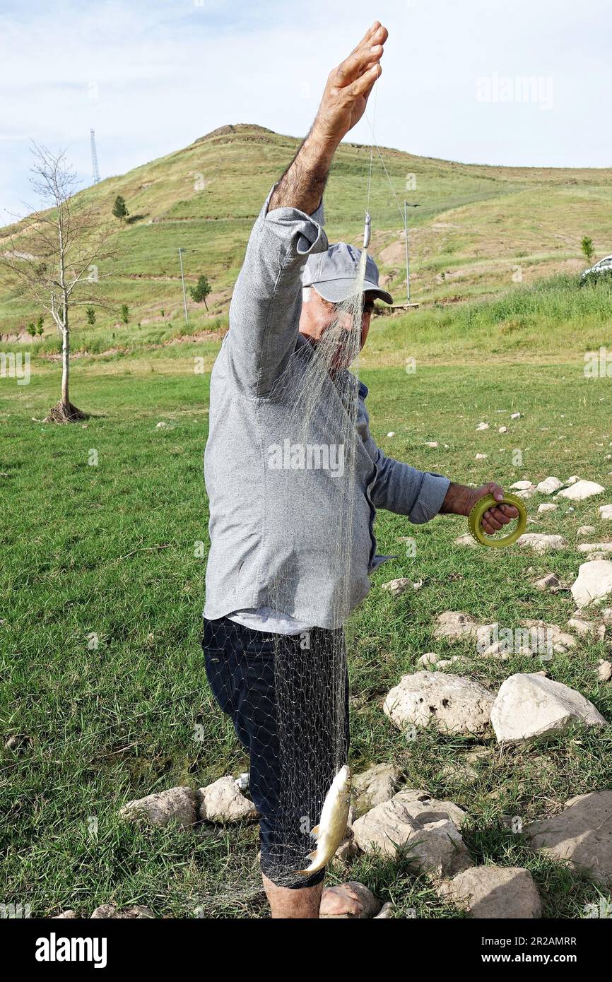 May 17, 2023, Diyarbakir, Turkey: A fisherman displays fish he caught ...