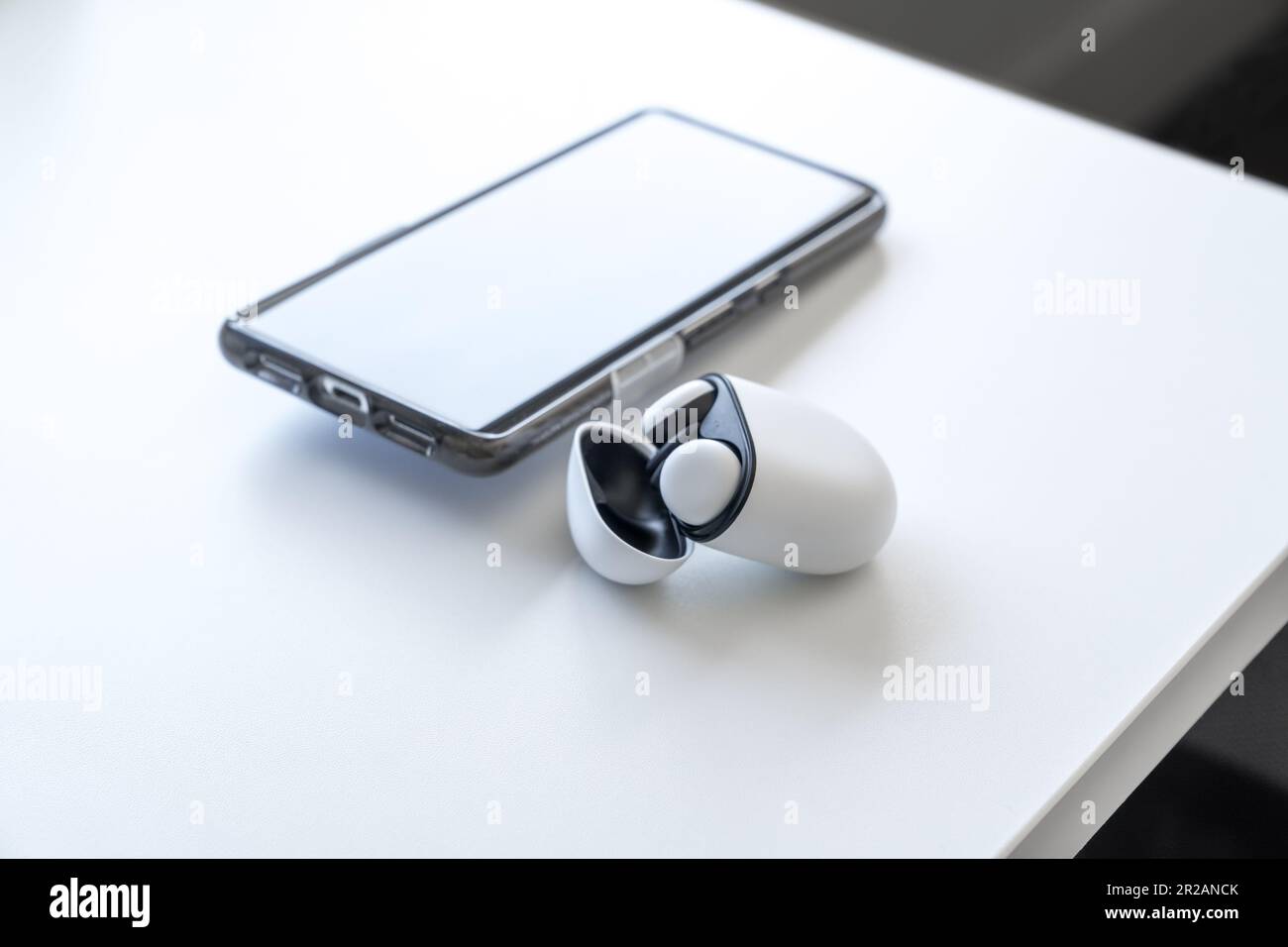 Wireless earbud headphones in their case, with the lid open, sitting on ...