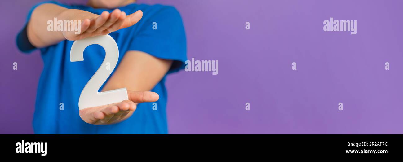 White number 2 in hand. The hand holding the number 2 symbolizes choice ...