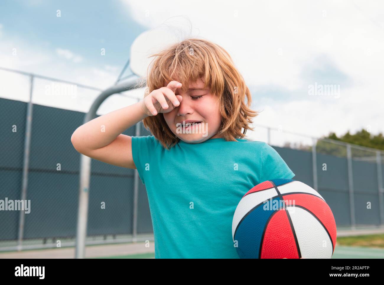 Boy cries of resentment and grief. Little boy alone, lonely with ball ...