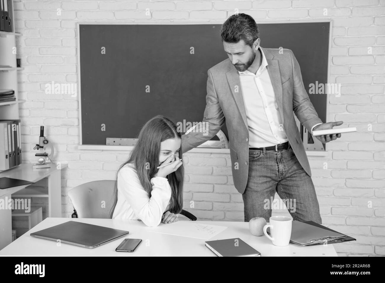 laughing child study in classroom with confused teacher Stock Photo - Alamy