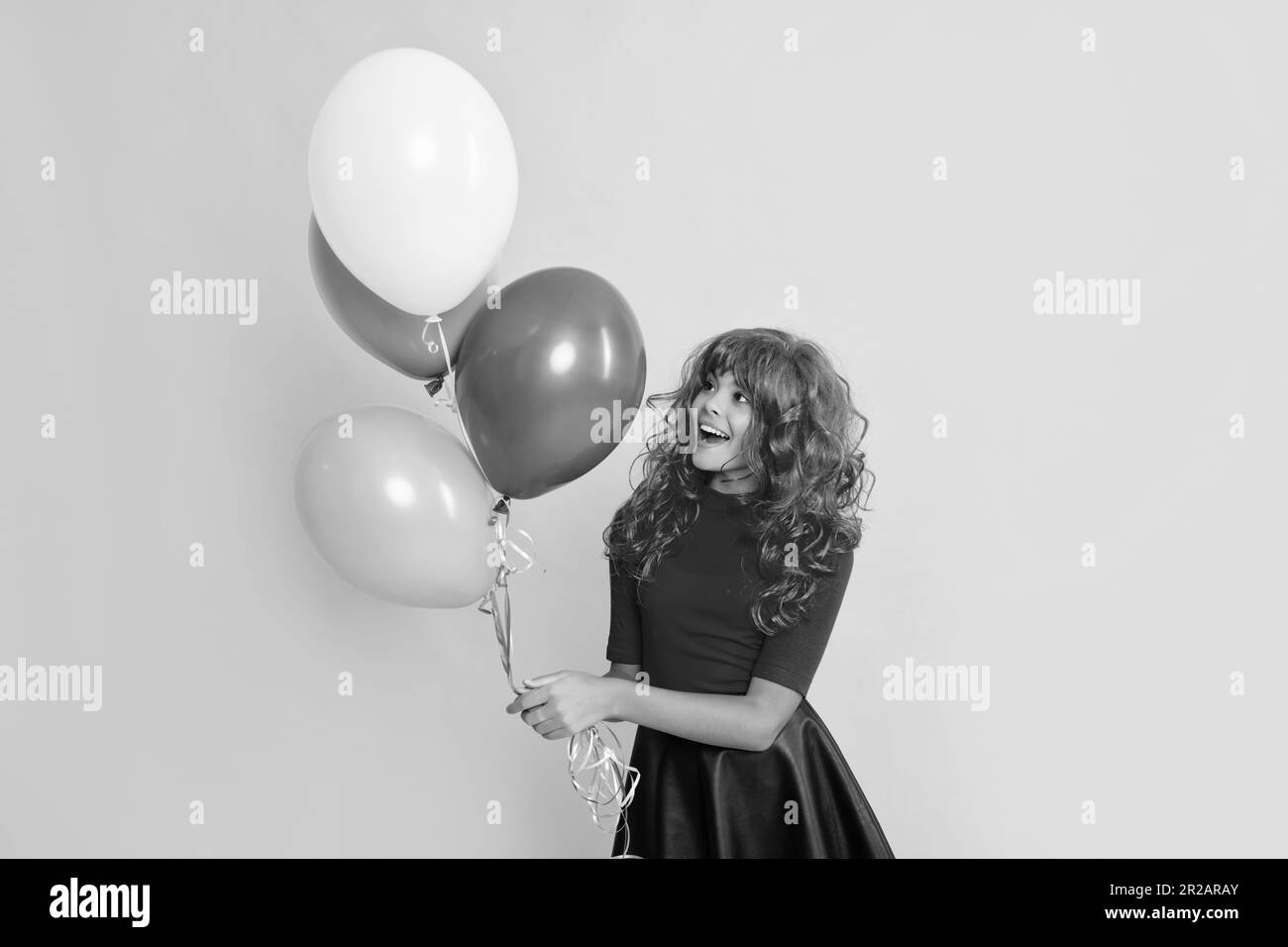 positive child with party balloon on yellow background Stock Photo - Alamy