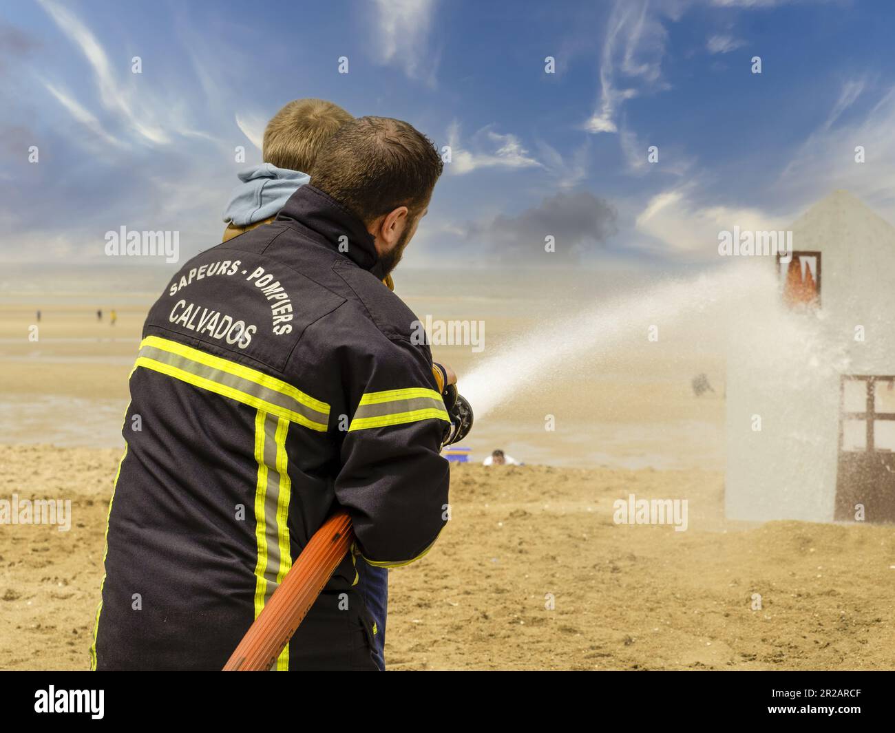 Houlgate, France May 2023. A firefighter with a hose to put out fires ...