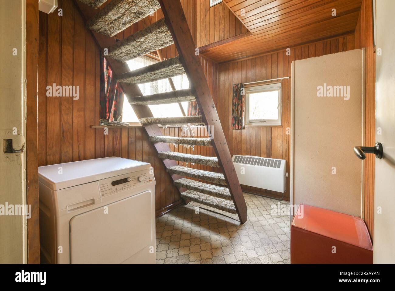 a laundry room with wood paneled walls and white washer in the corner ...