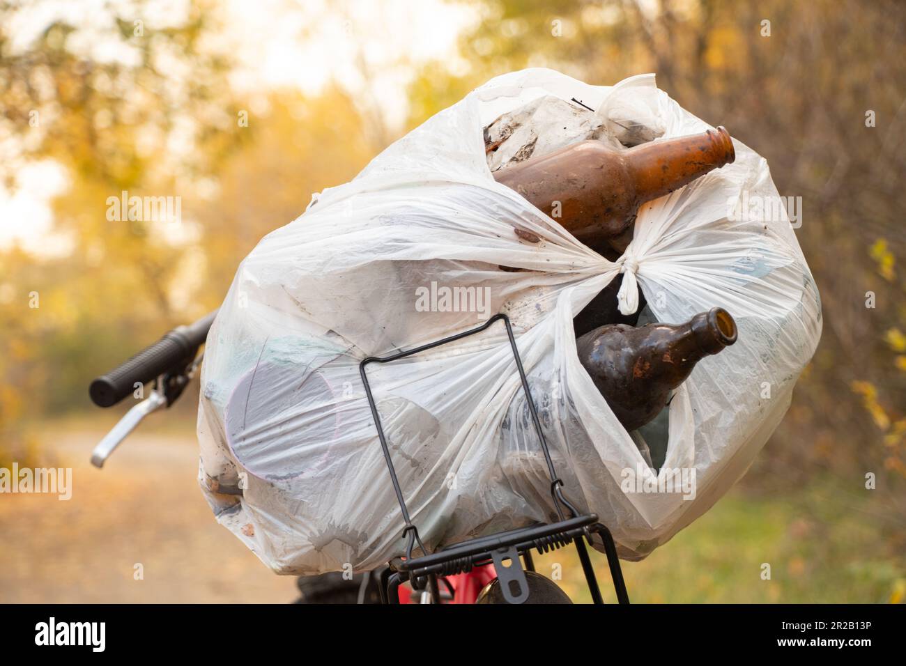 garbage bag on a bicycle in the forest in autumn, garbage collection in ...