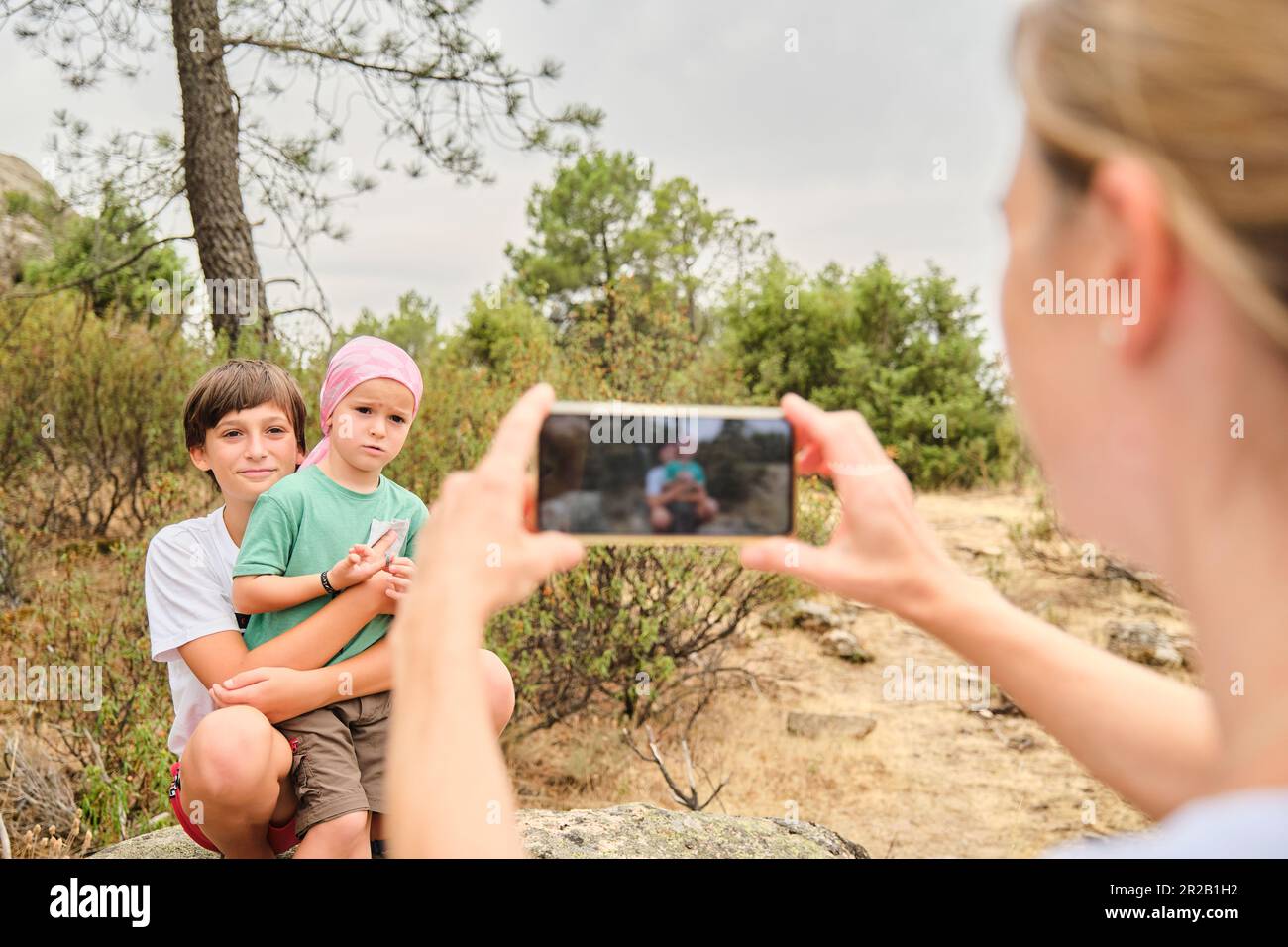 Mother taking a photograph of her children in nature Stock Photo - Alamy