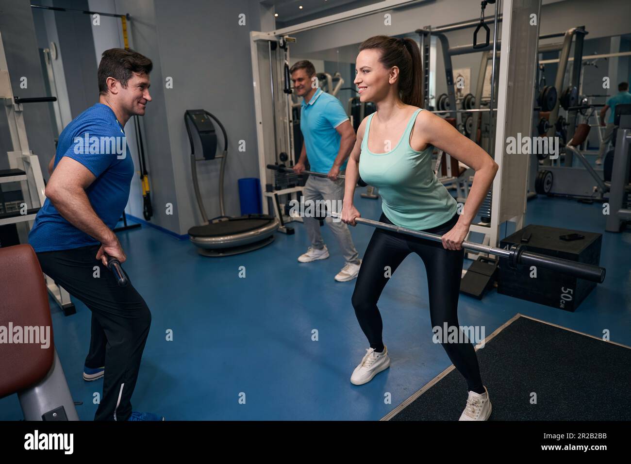 Mature couple doing strength training with personal trainer Stock Photo ...