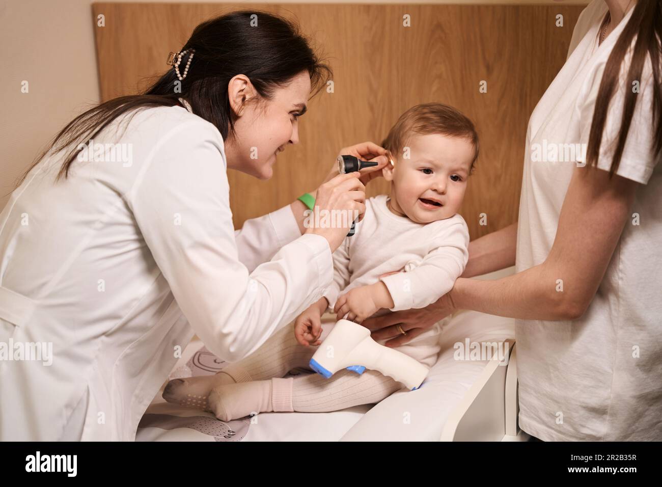 Friendly ENT doctor conducting ear examination on little child Stock ...