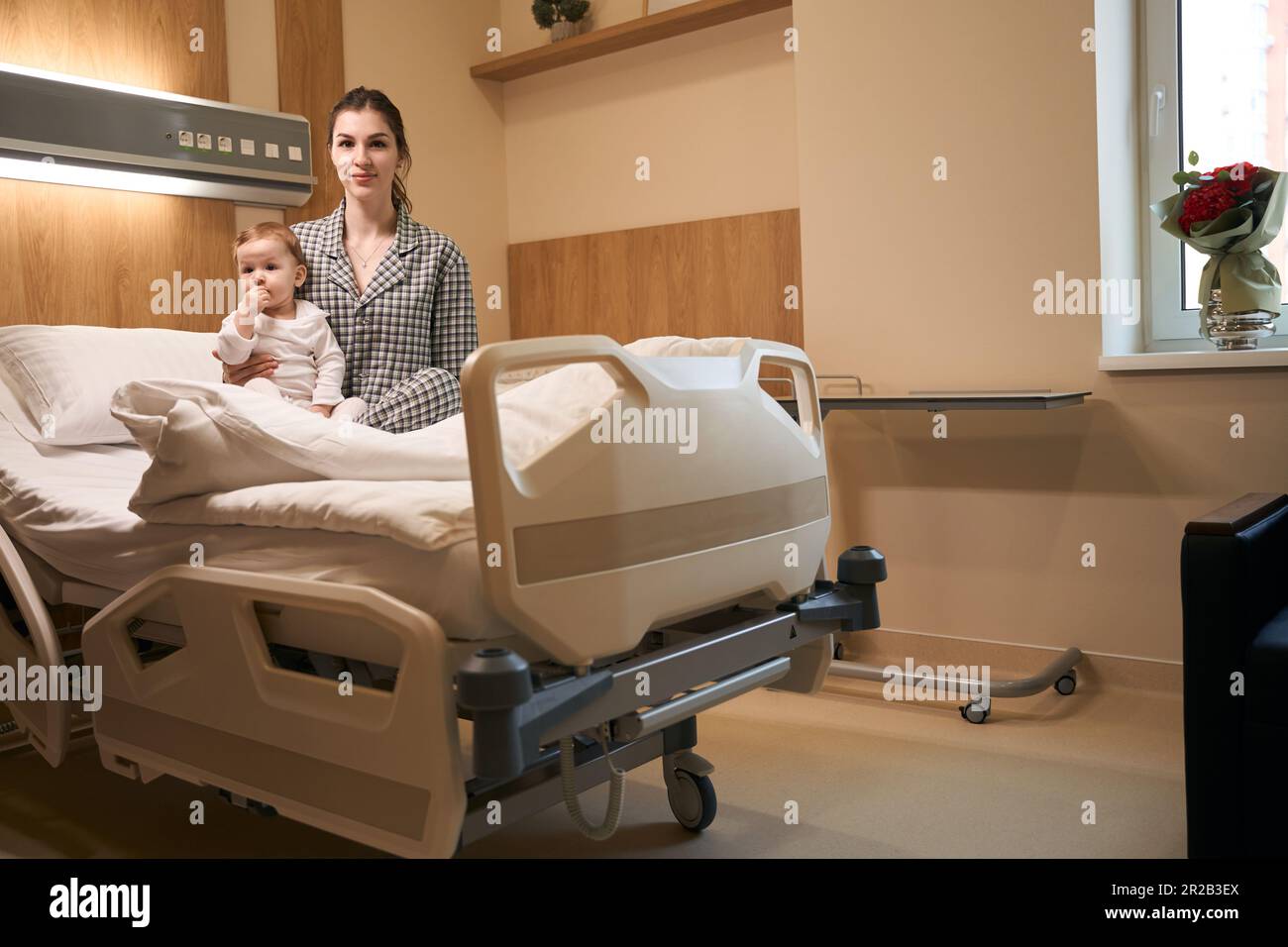 Female parent staying with ill baby in pediatric hospital Stock Photo ...
