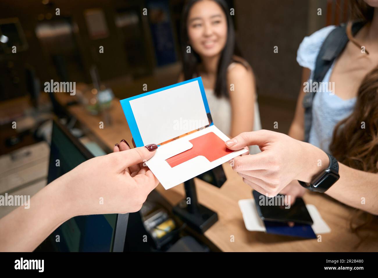 Handing over key to hotel room at reception to visitors Stock Photo - Alamy