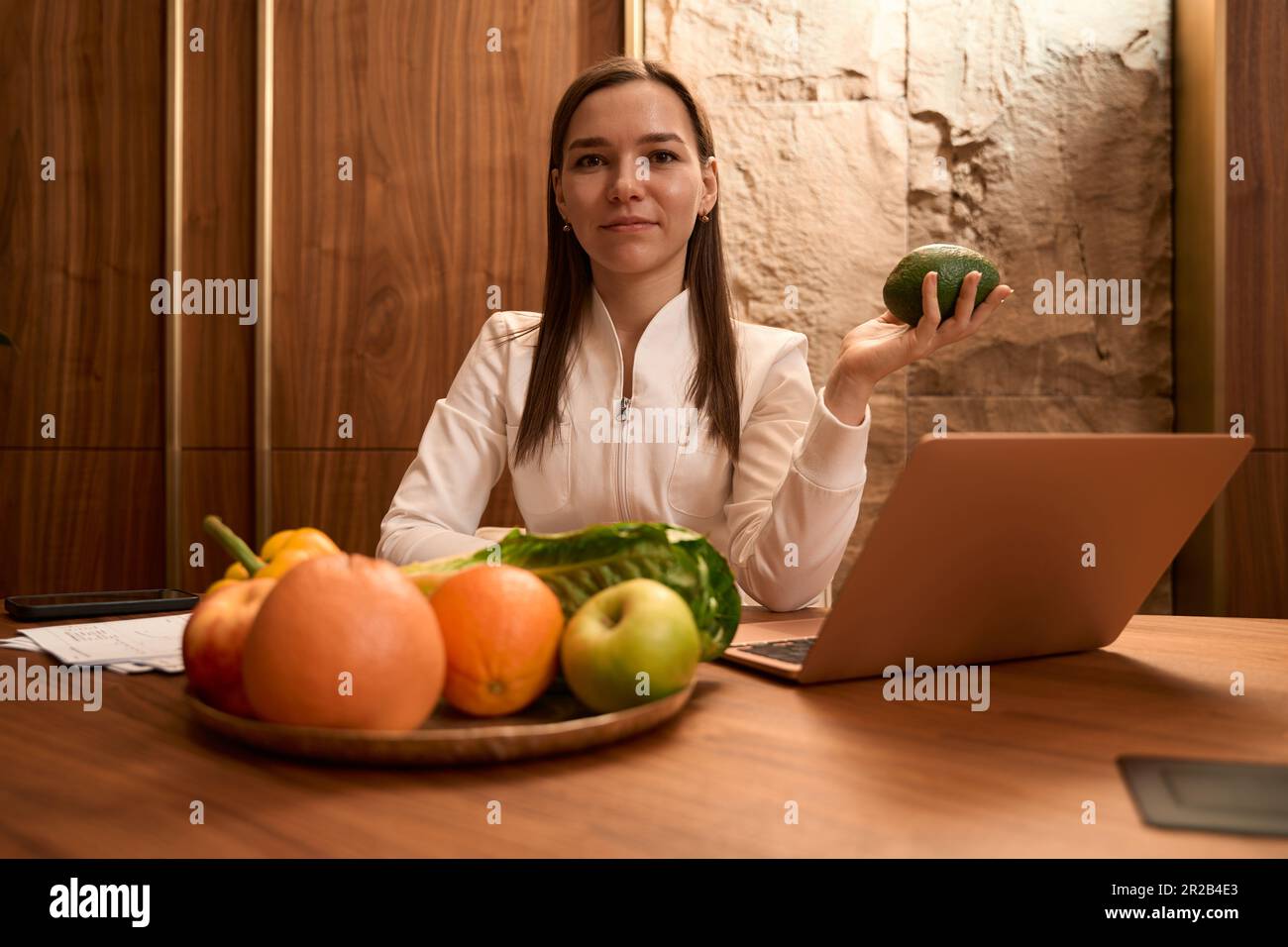 Young nutritionist holding vegetable in her hand Stock Photo - Alamy