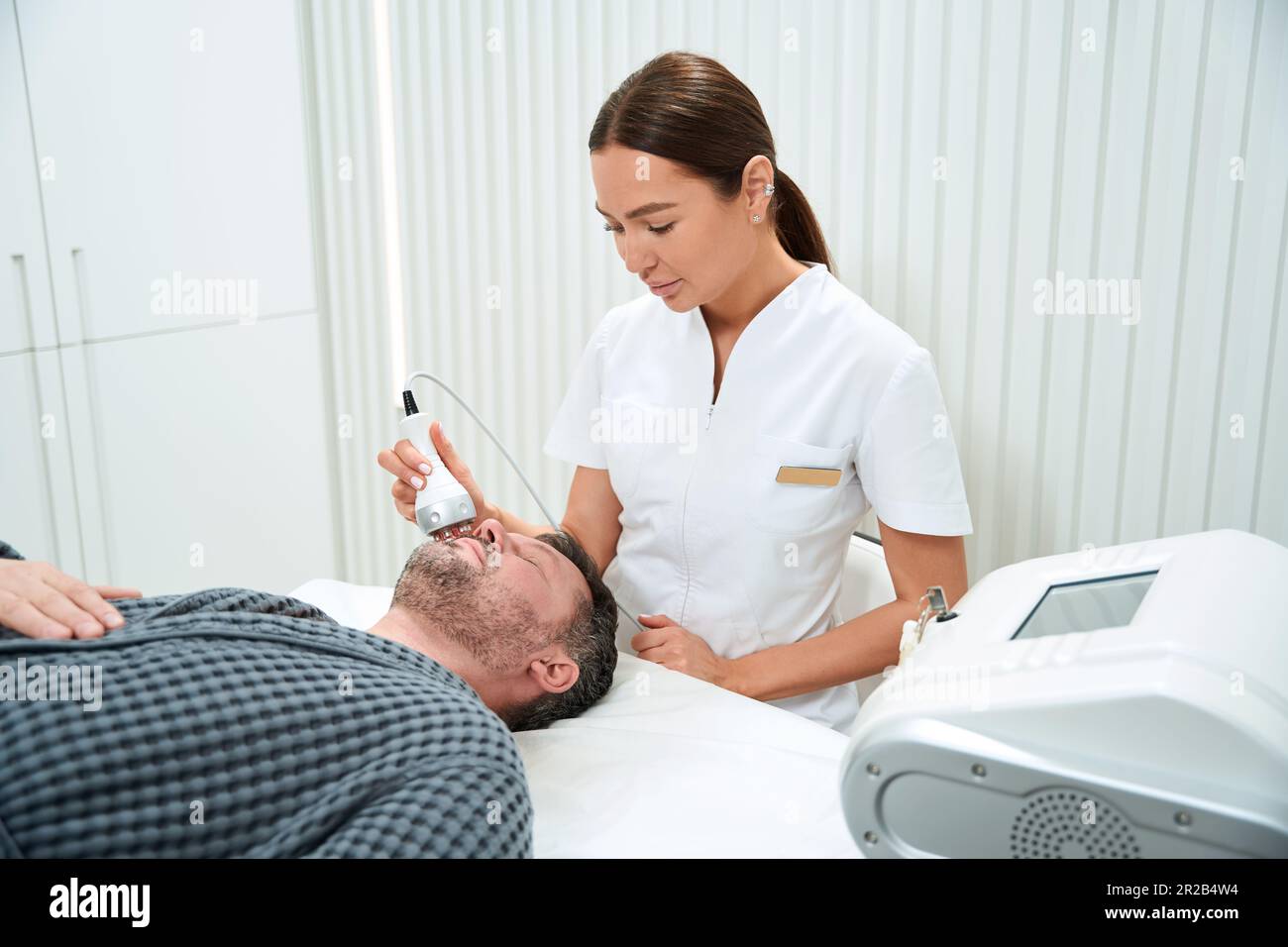 Nurse performing procedure on man face in the spa Stock Photo - Alamy