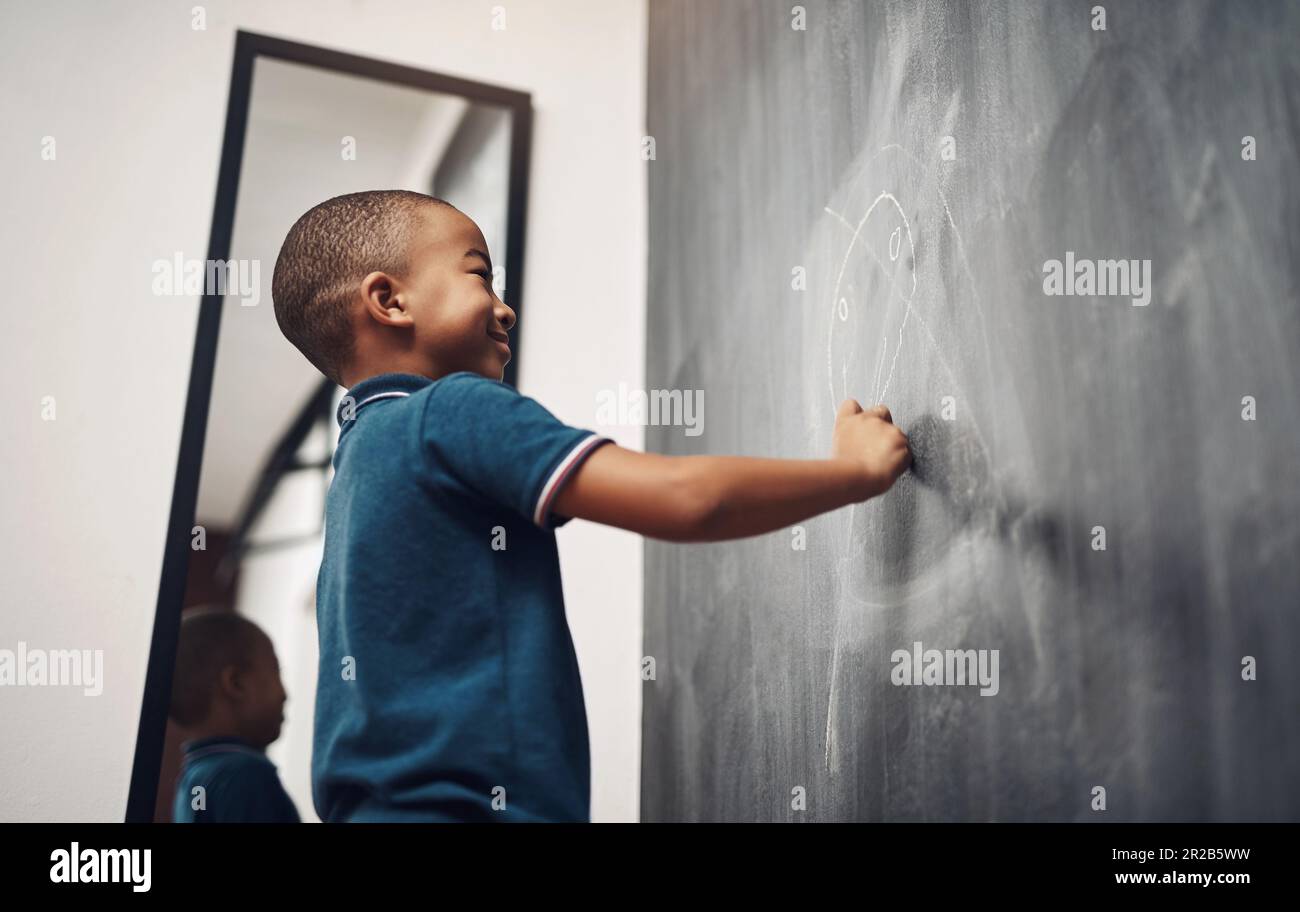 We express ourselves through visual art. a young boy writing on a ...