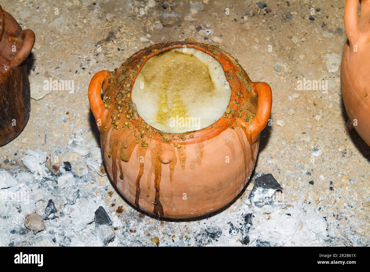Ancient food delicacies. Cooking lentils soup in a clay cookware pot ...