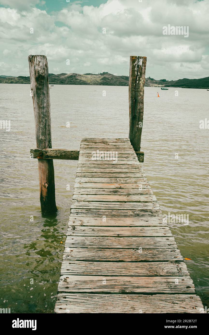 Weathered and worn old pier at Rawene vintage effect in vertical composition Stock Photo - Alamy
