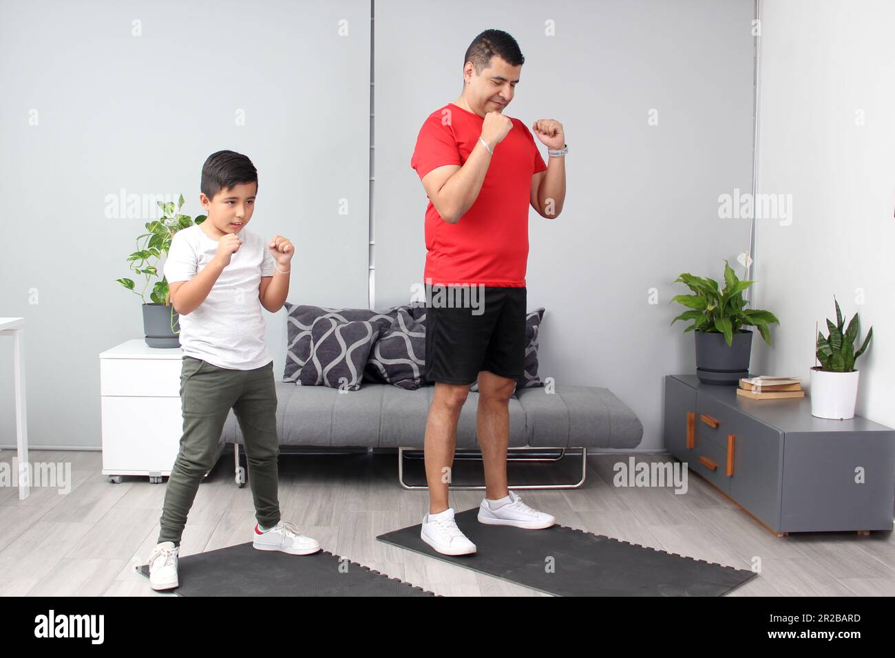 Boxing classes in the living room of his house between dad and son as a ...