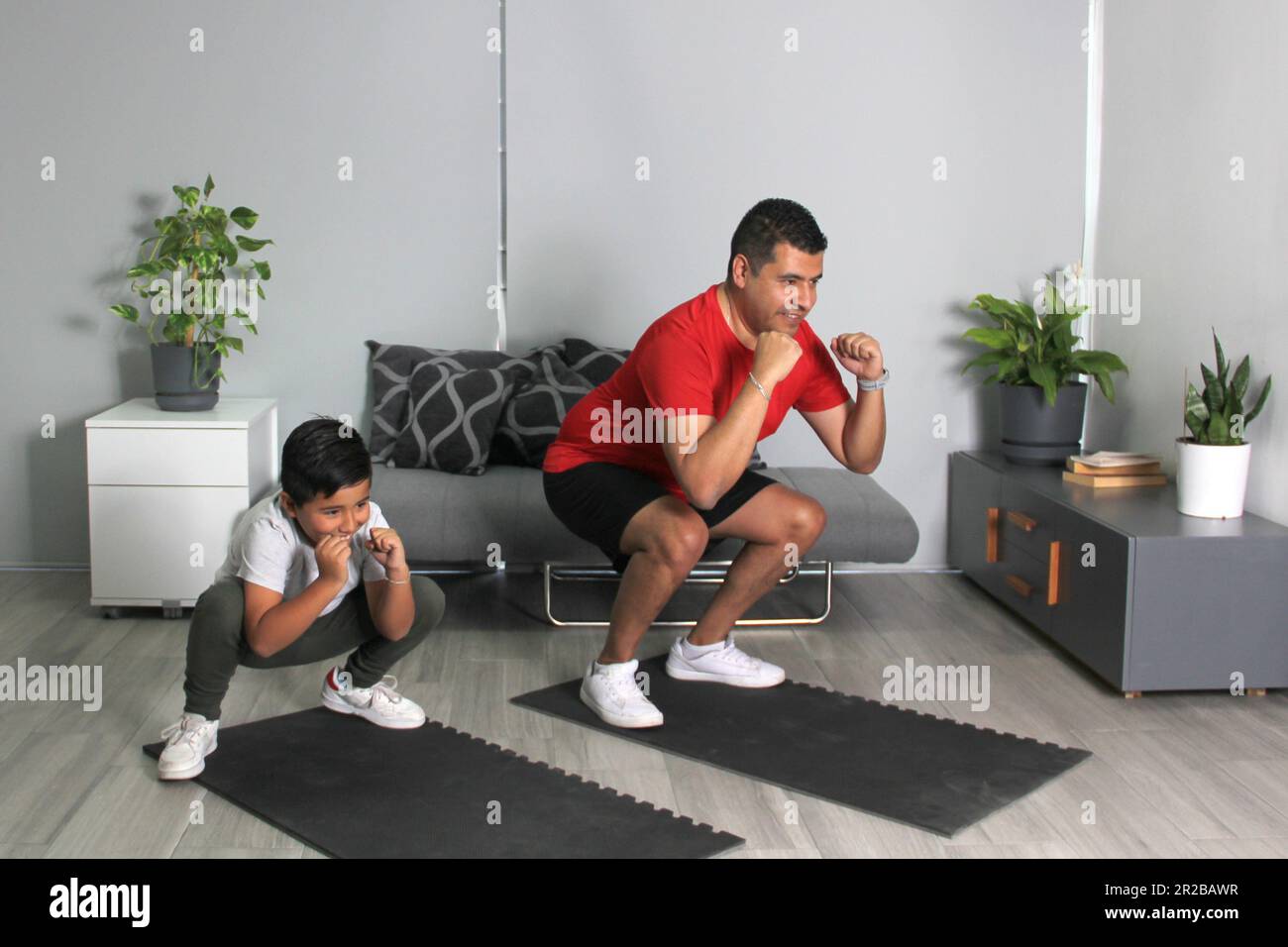 Boxing classes in the living room of his house between dad and son as a ...