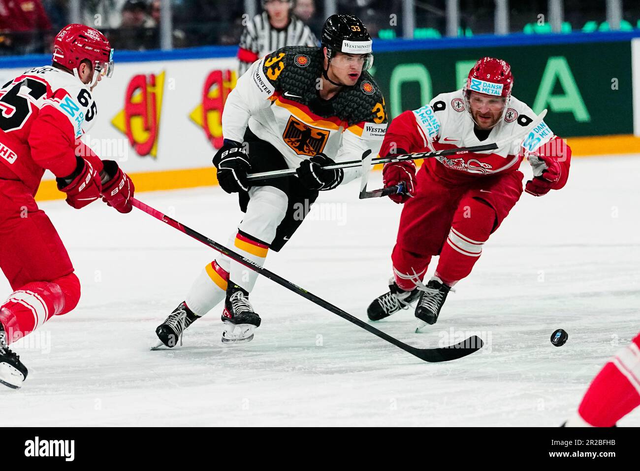 Germany's John Peterka, centre, battles for the puck with Denmark's ...