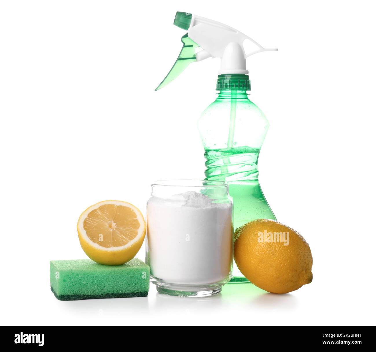 Glass of baking soda, sprayer, lemons and cleaning sponge on white ...