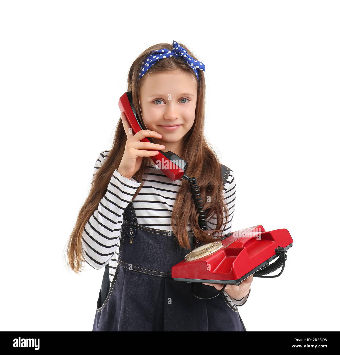 Little girl talking by telephone on white background Stock Photo - Alamy