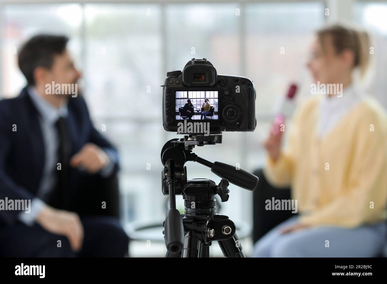 Female journalist with microphone having an interview with man on ...
