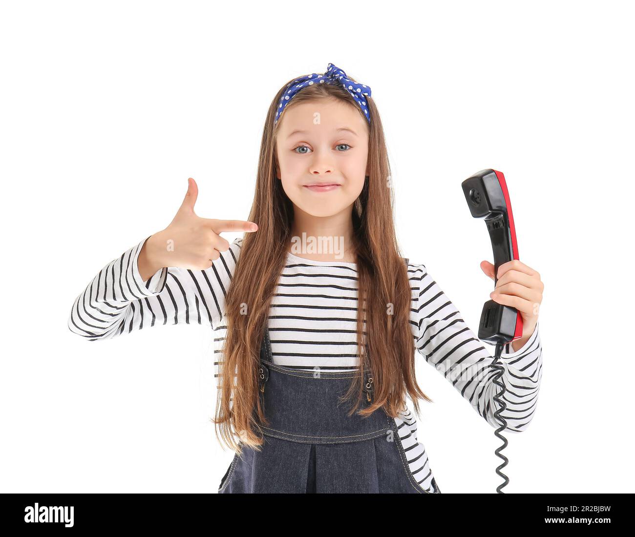 Little girl pointing at phone receiver on white background Stock Photo ...