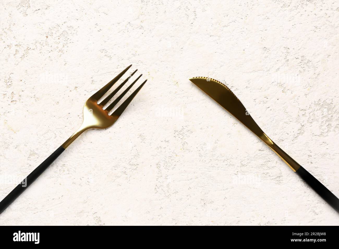 Golden fork and knife with black handles on white background Stock ...