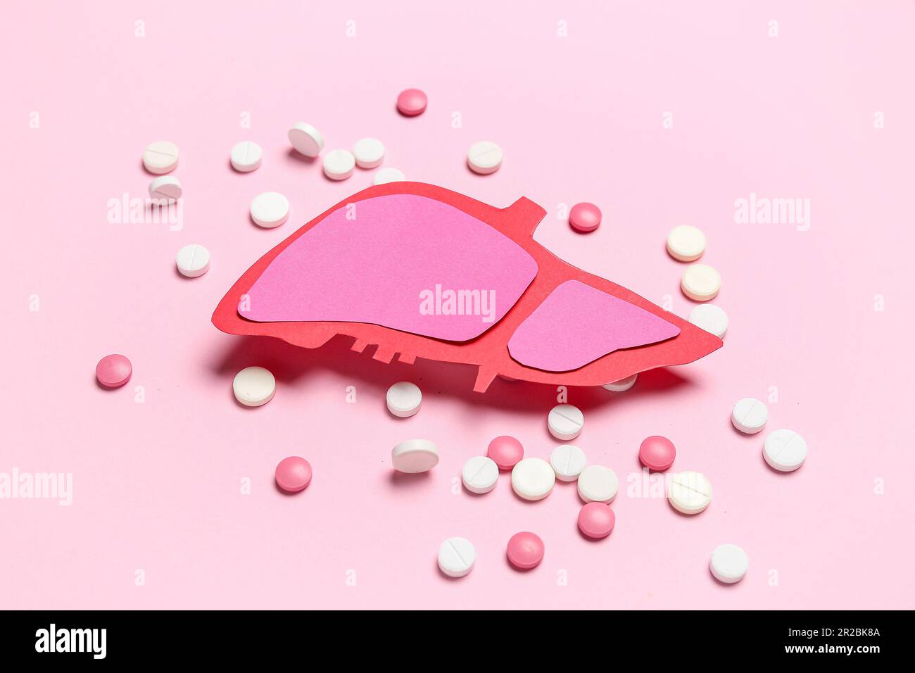 Paper liver with pills on pink background Stock Photo - Alamy