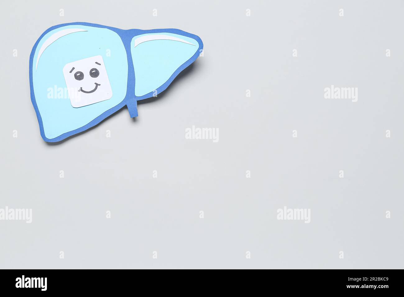 Blue paper liver with smiling face on grey background Stock Photo - Alamy