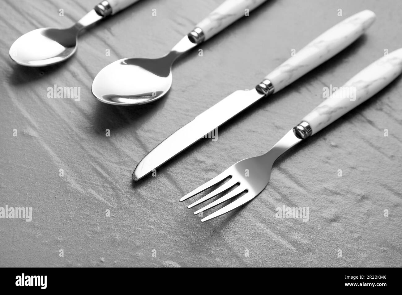 Stainless steel cutlery with plastic handles on grey background Stock ...