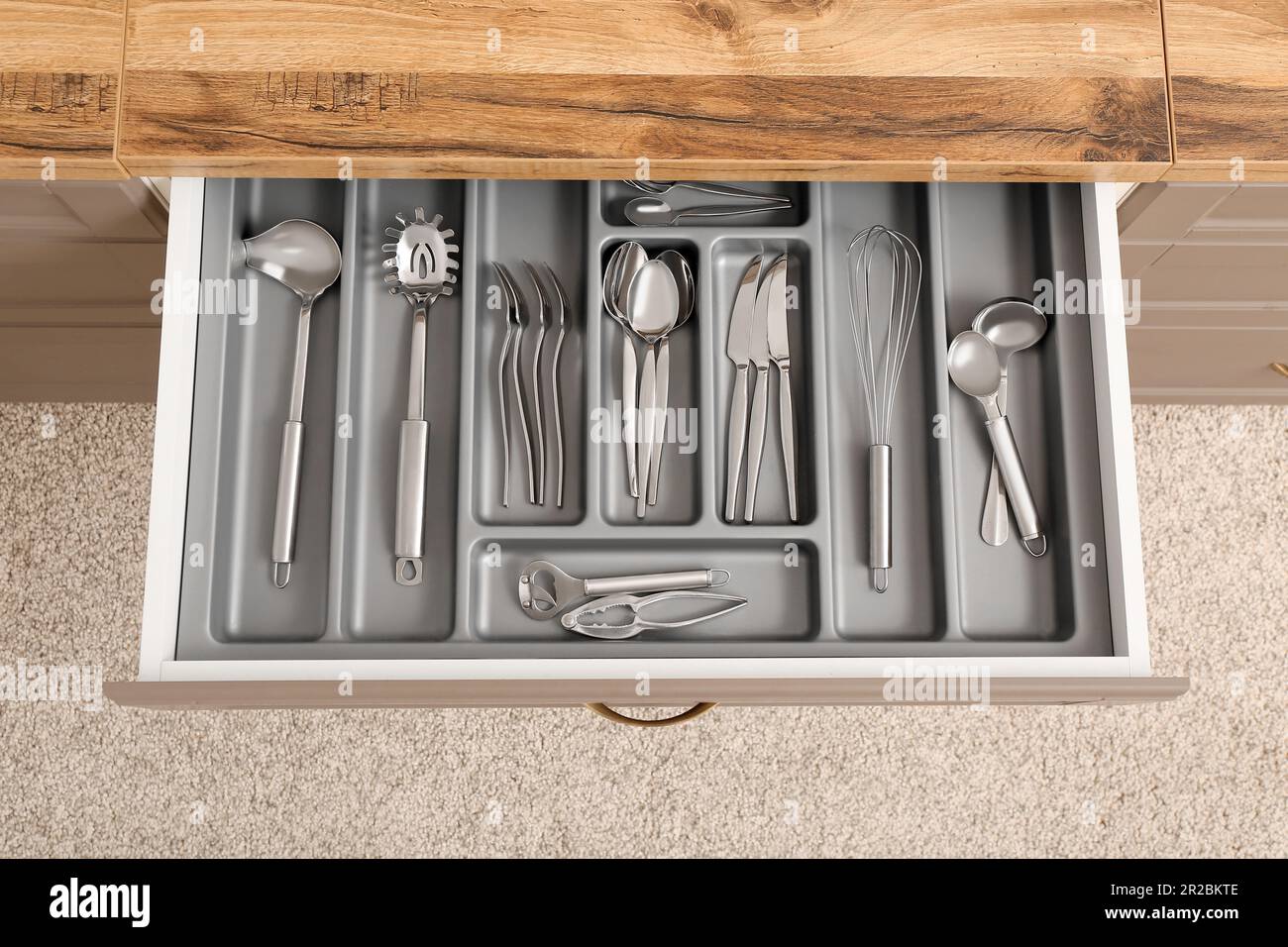 Open kitchen drawer with different silver cutlery Stock Photo - Alamy