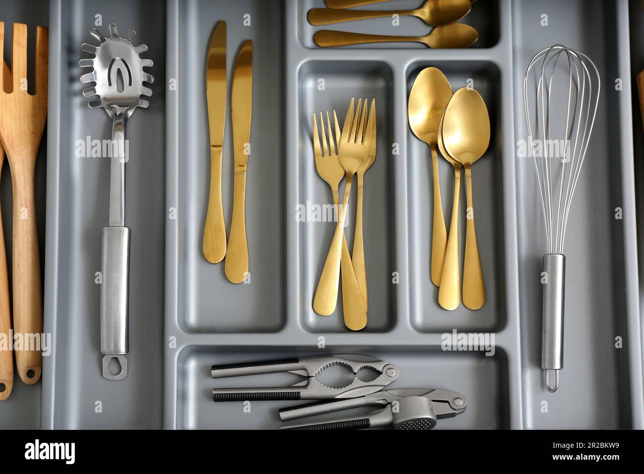 Open kitchen drawer with different gold cutlery Stock Photo - Alamy