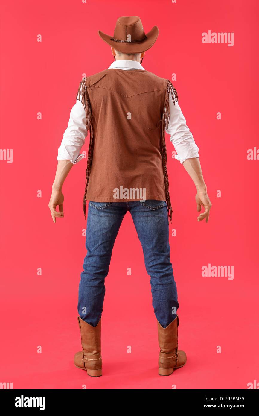 Handsome cowboy on red background, back view Stock Photo - Alamy