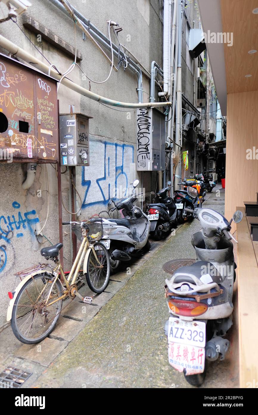 Narrow alley between buildings in Taipei, Taiwan; parked bicycles and ...