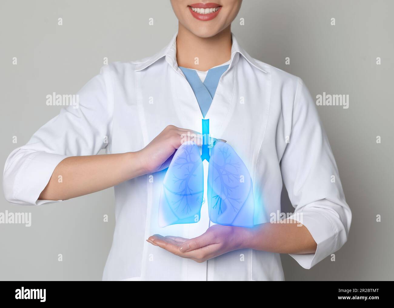 Doctor demonstrating digital image of human lungs on light background ...