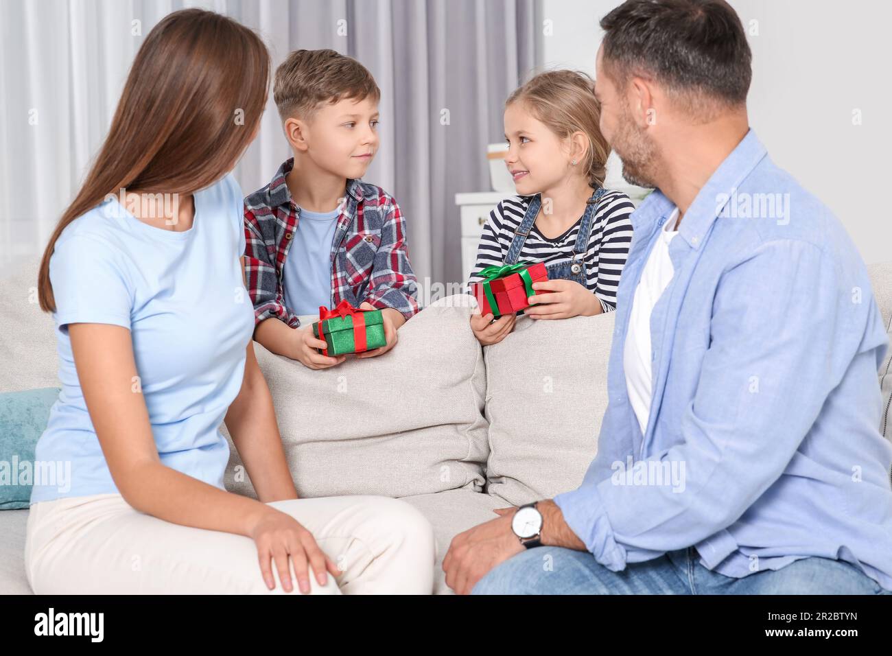 Little children presenting their parents with gifts at home Stock Photo ...