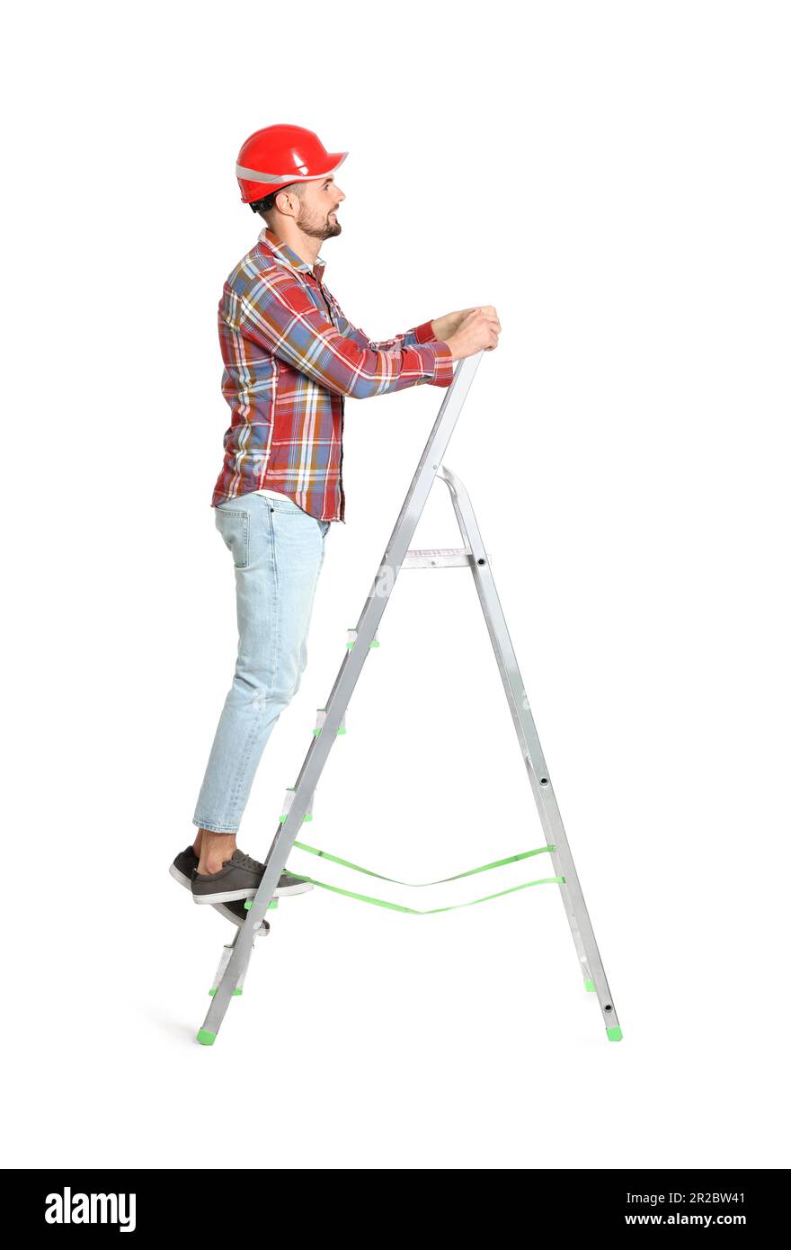 Young handsome man in hard hat climbing up metal ladder on white ...