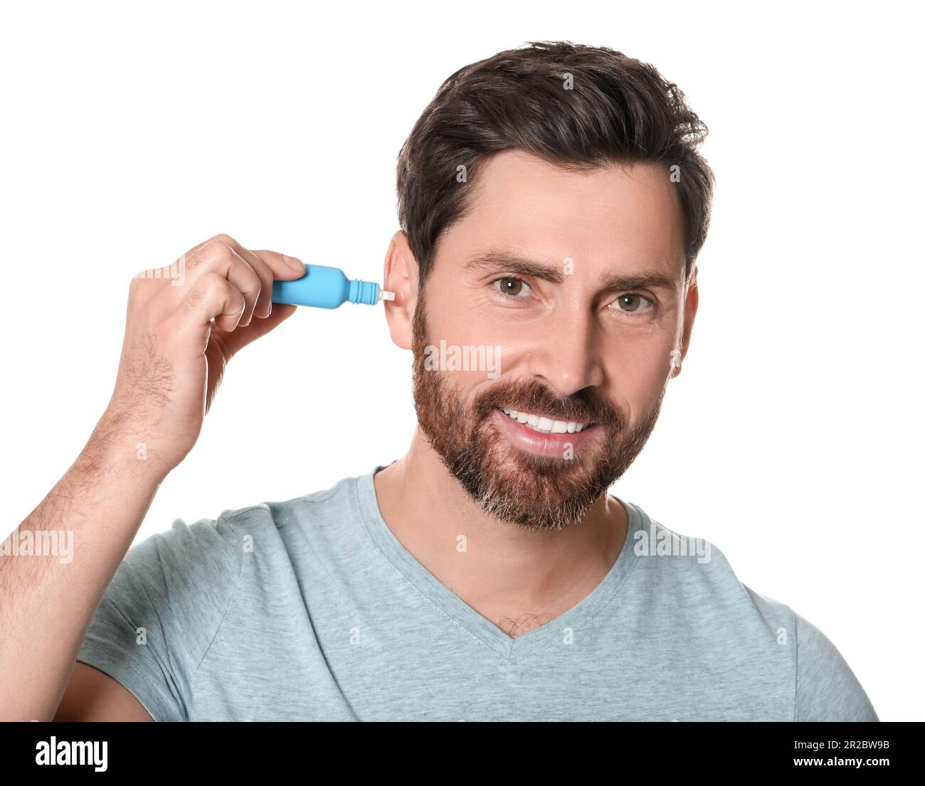Man using ear drops on white background Stock Photo - Alamy