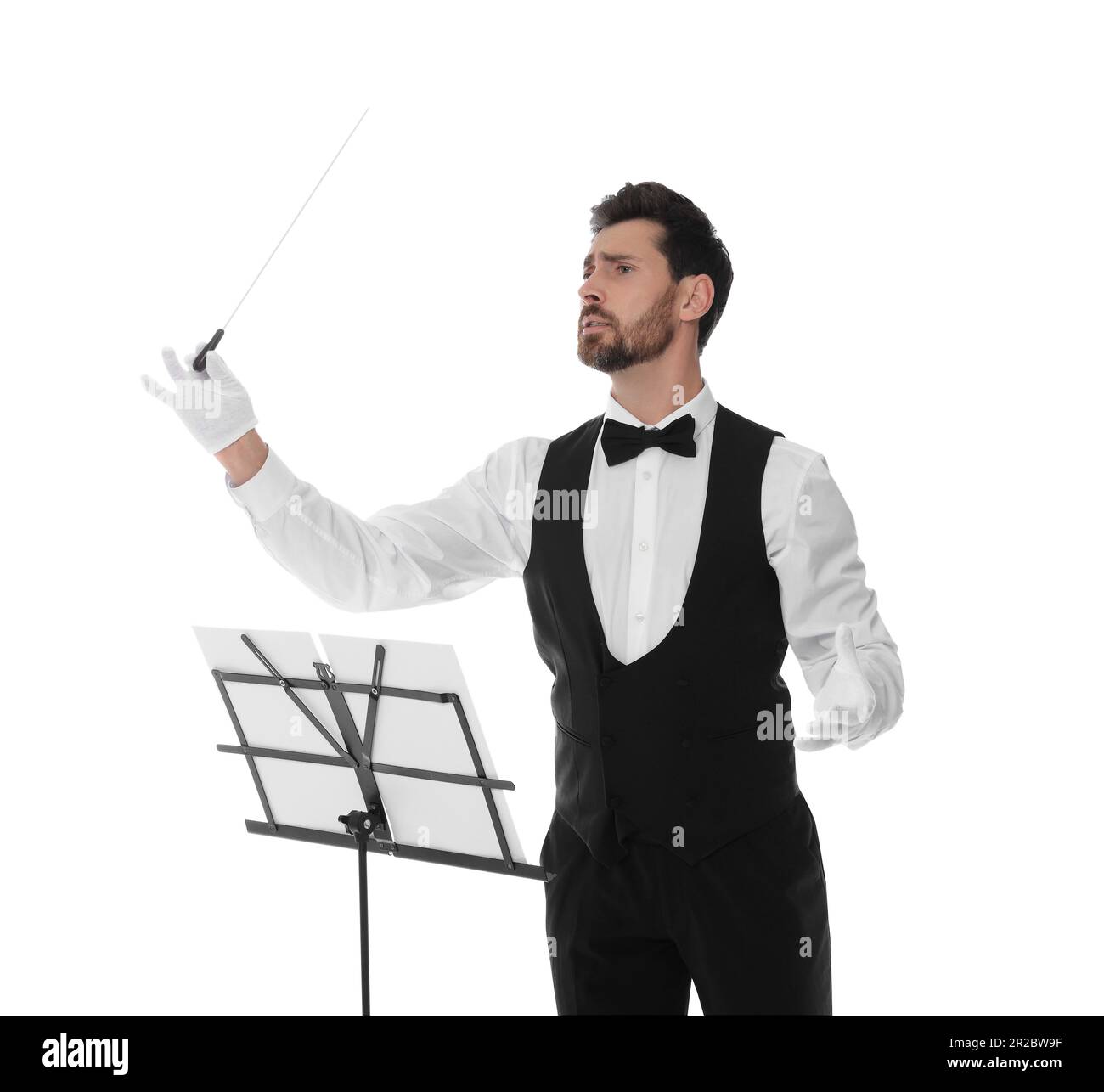 Professional conductor with baton and note stand on white background ...