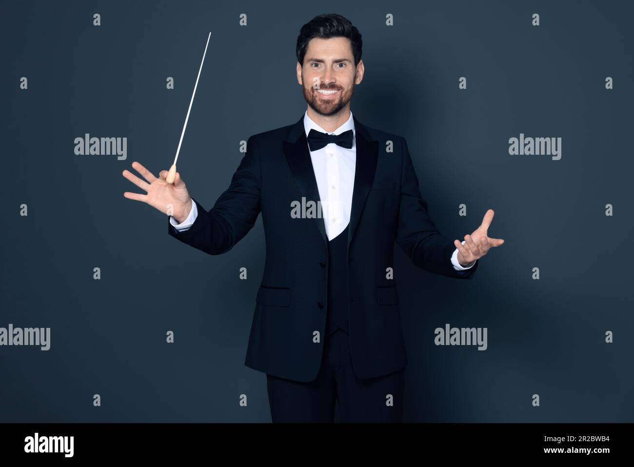 Happy professional conductor with baton on grey background Stock Photo ...