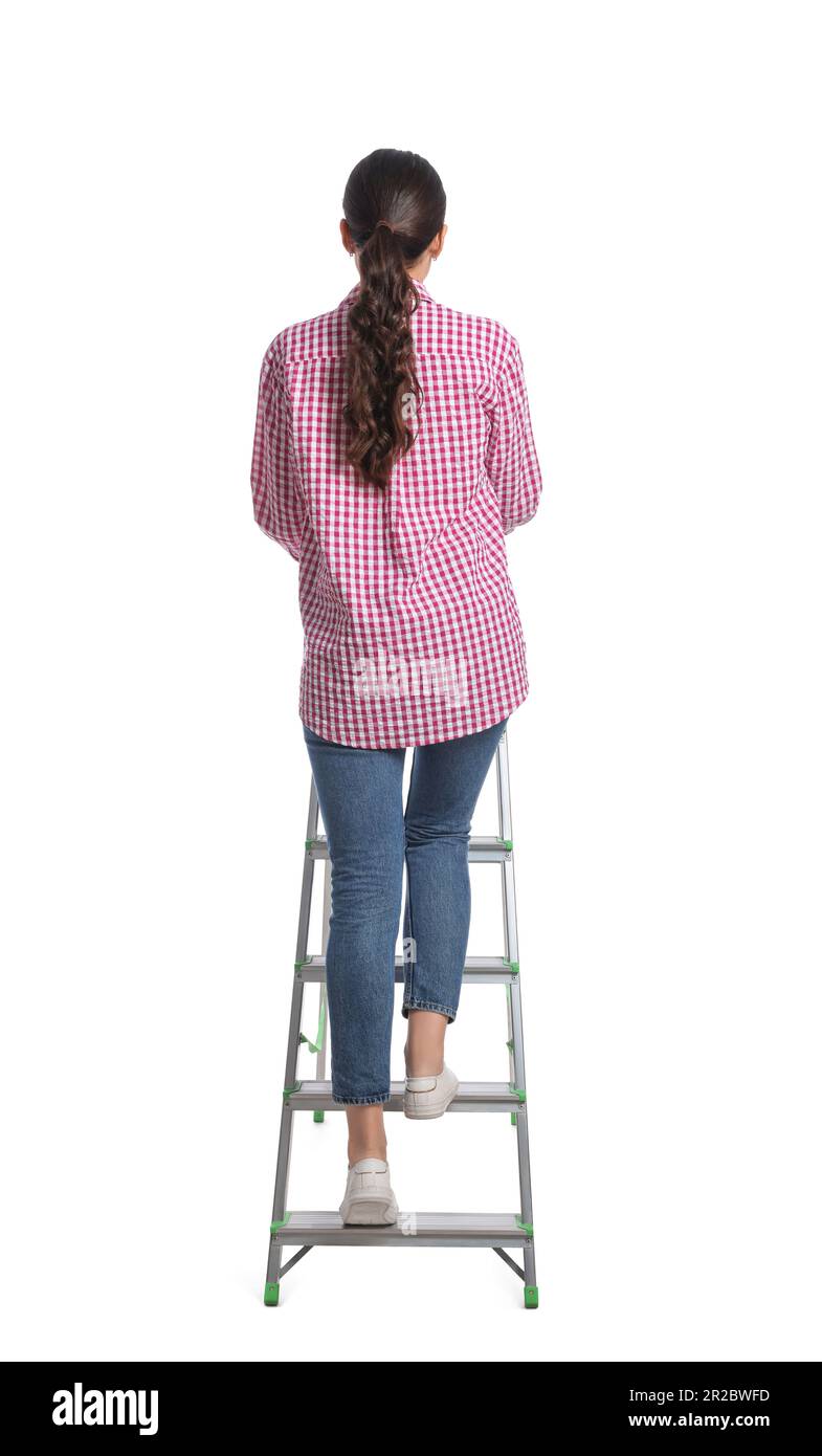 Young woman climbing up metal ladder on white background, back view ...
