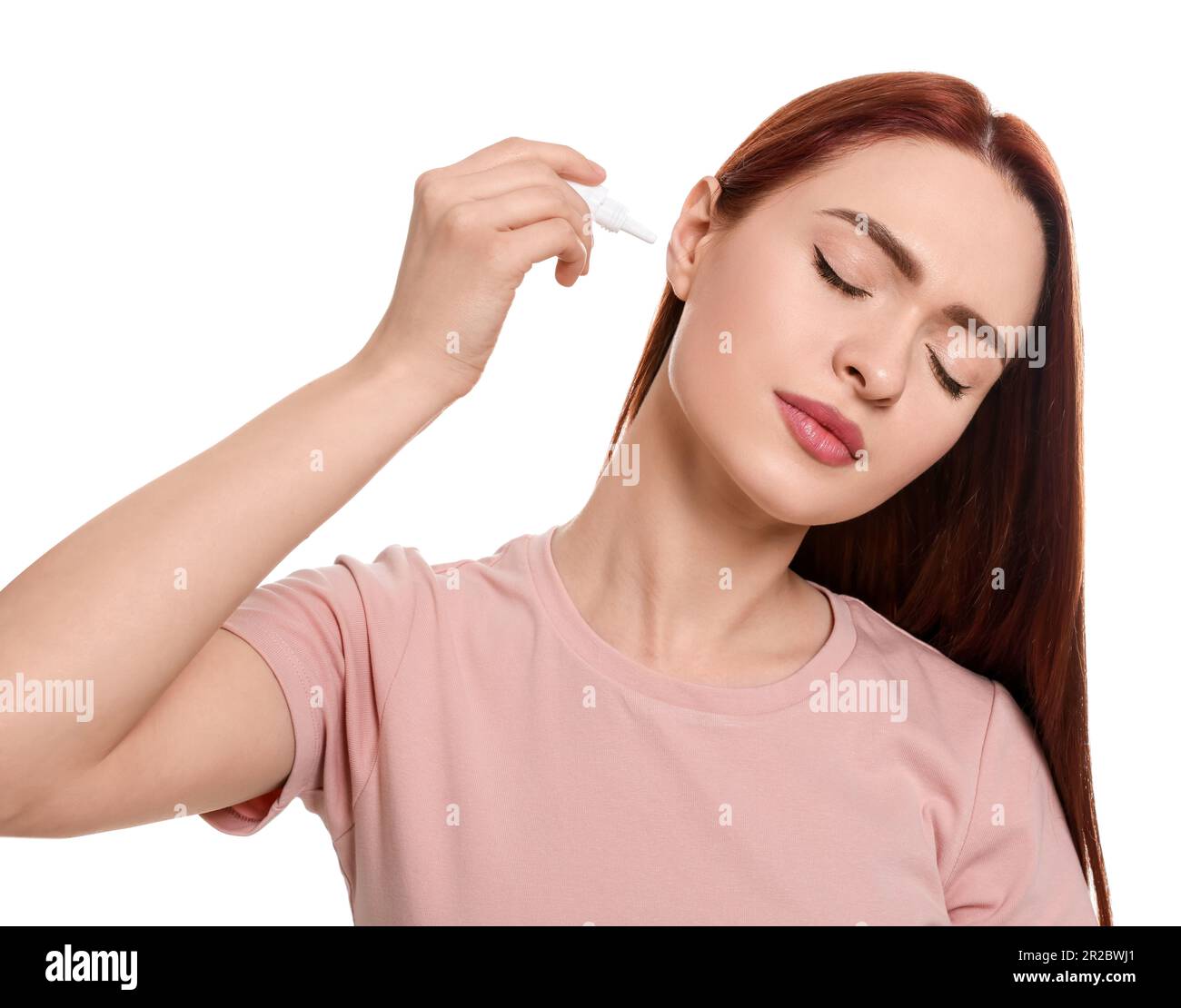 Woman using ear drops on white background Stock Photo - Alamy