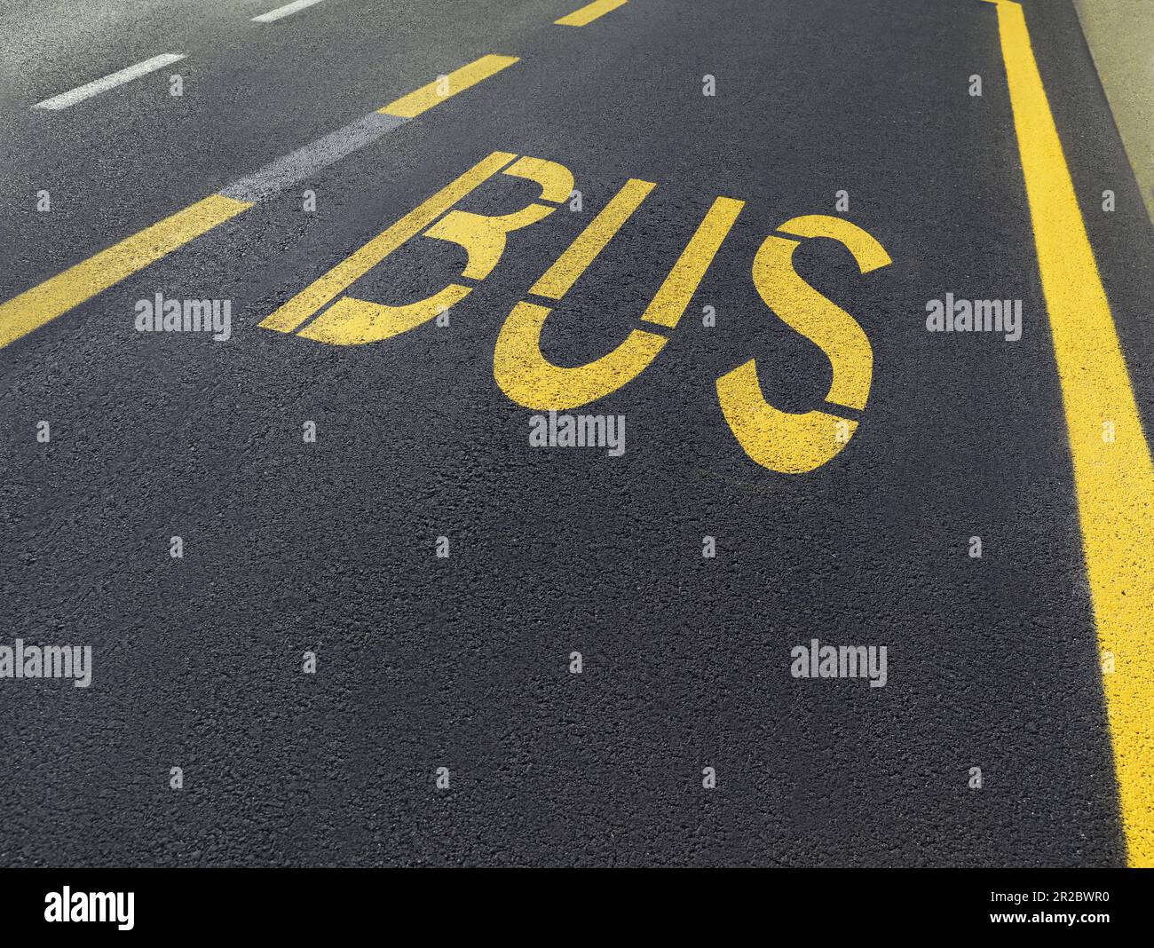 Bus stop pad on asphalt road on sunny day Stock Photo - Alamy