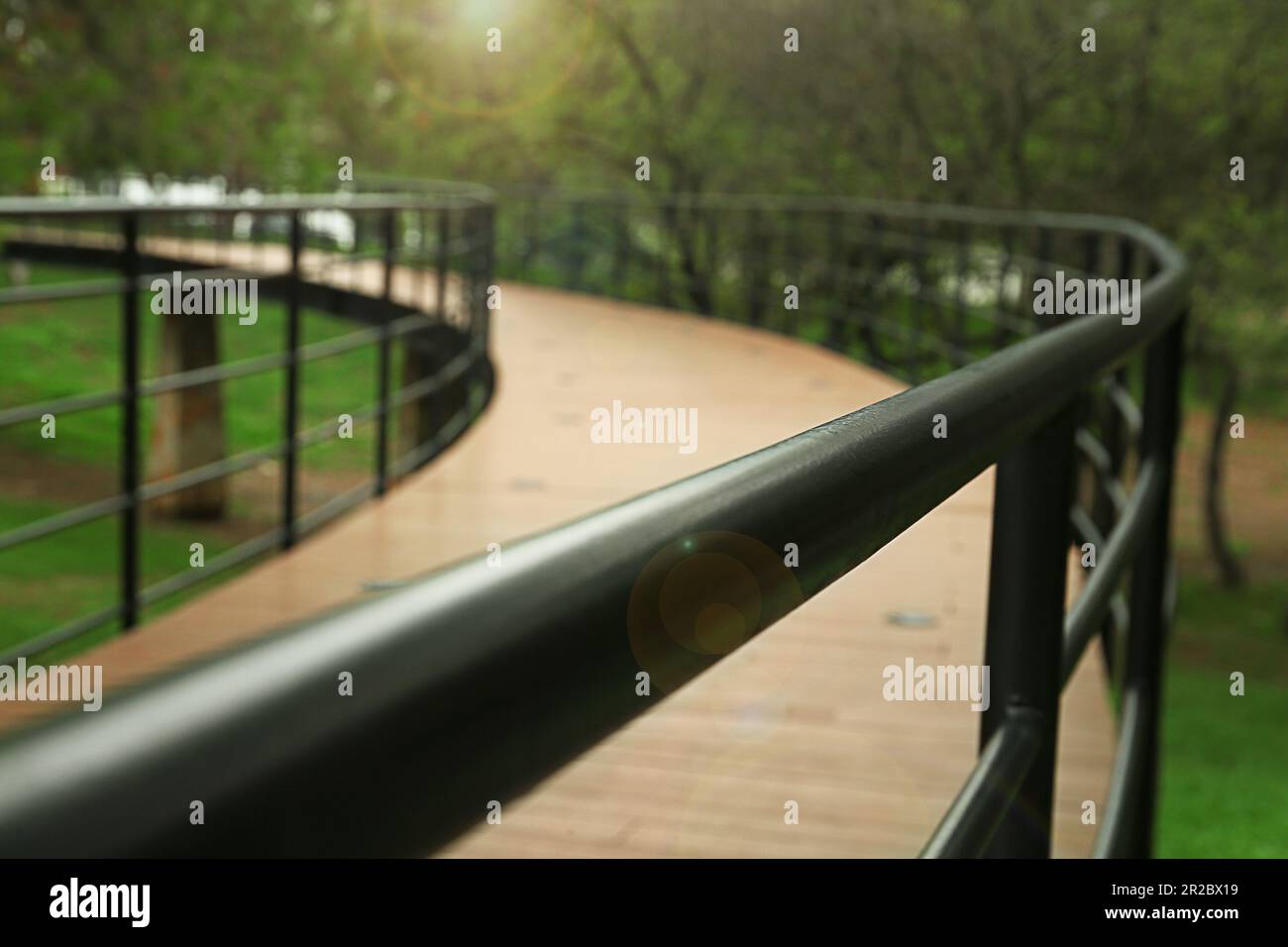 Beautiful pathway handrails in park near trees Stock Photo - Alamy