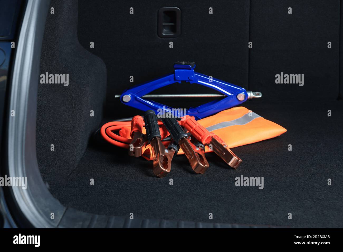 Scissor jack, life vest and battery jumper cables in trunk. Car safety ...
