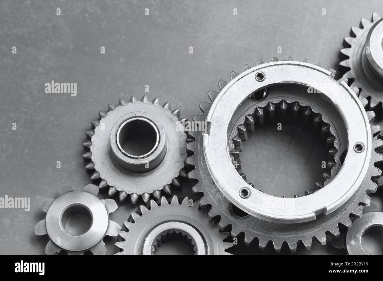 Different stainless steel gears on grey background, closeup. Space for ...