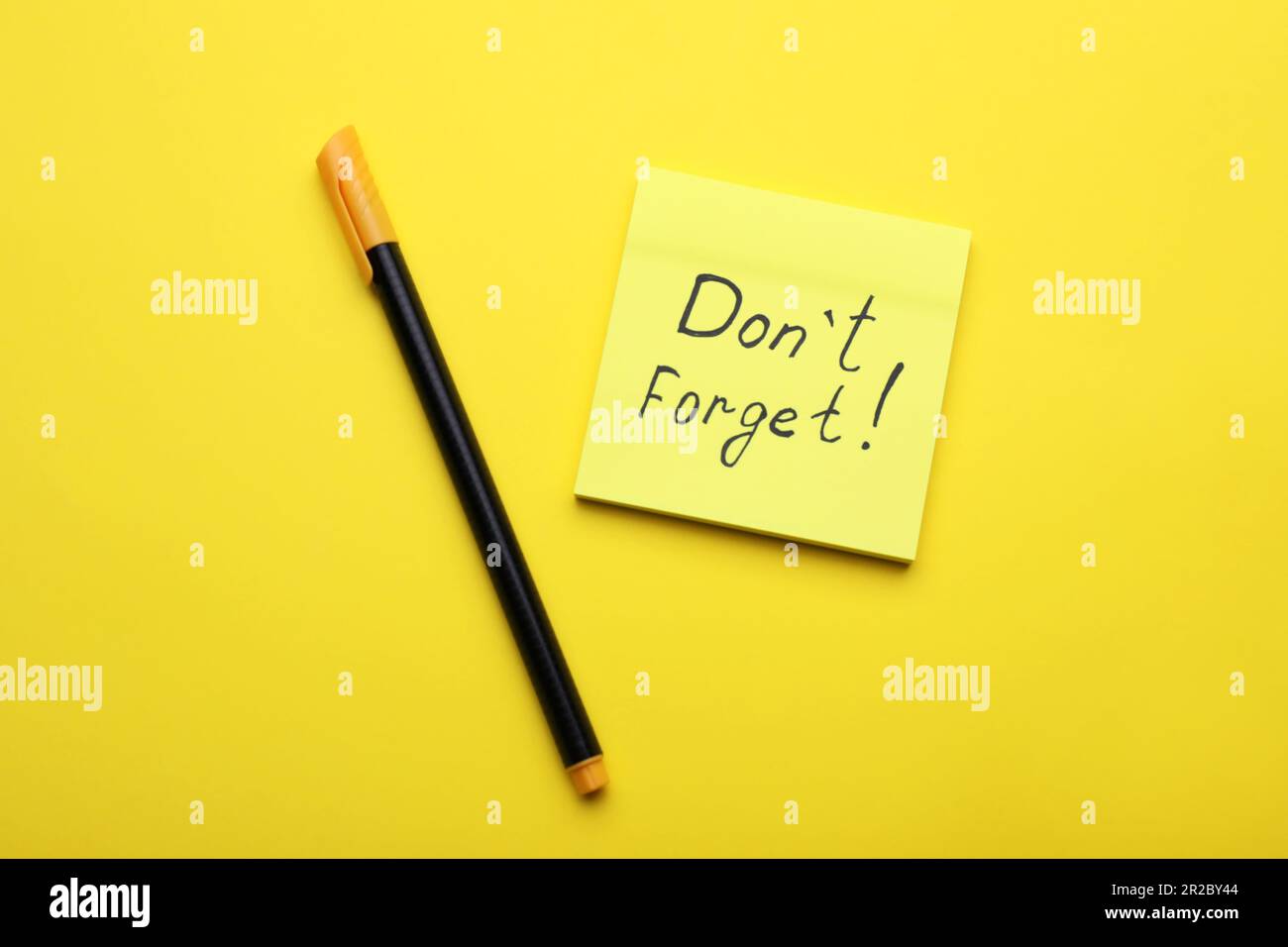 Paper note with phrase Don' t Forget and pen on yellow background, flat ...